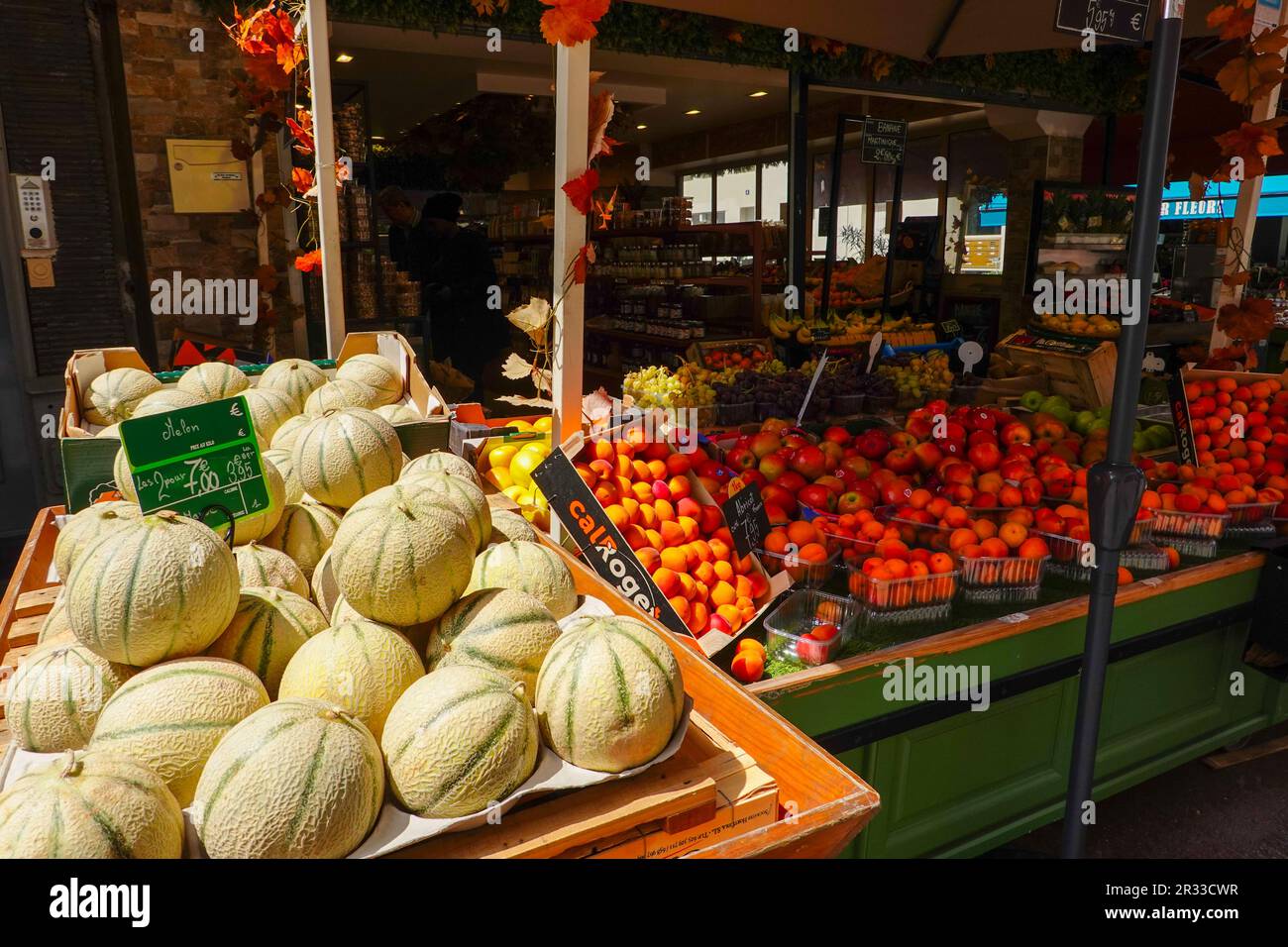 Fresh melons and other fruit attractively displayed outside a market on ...