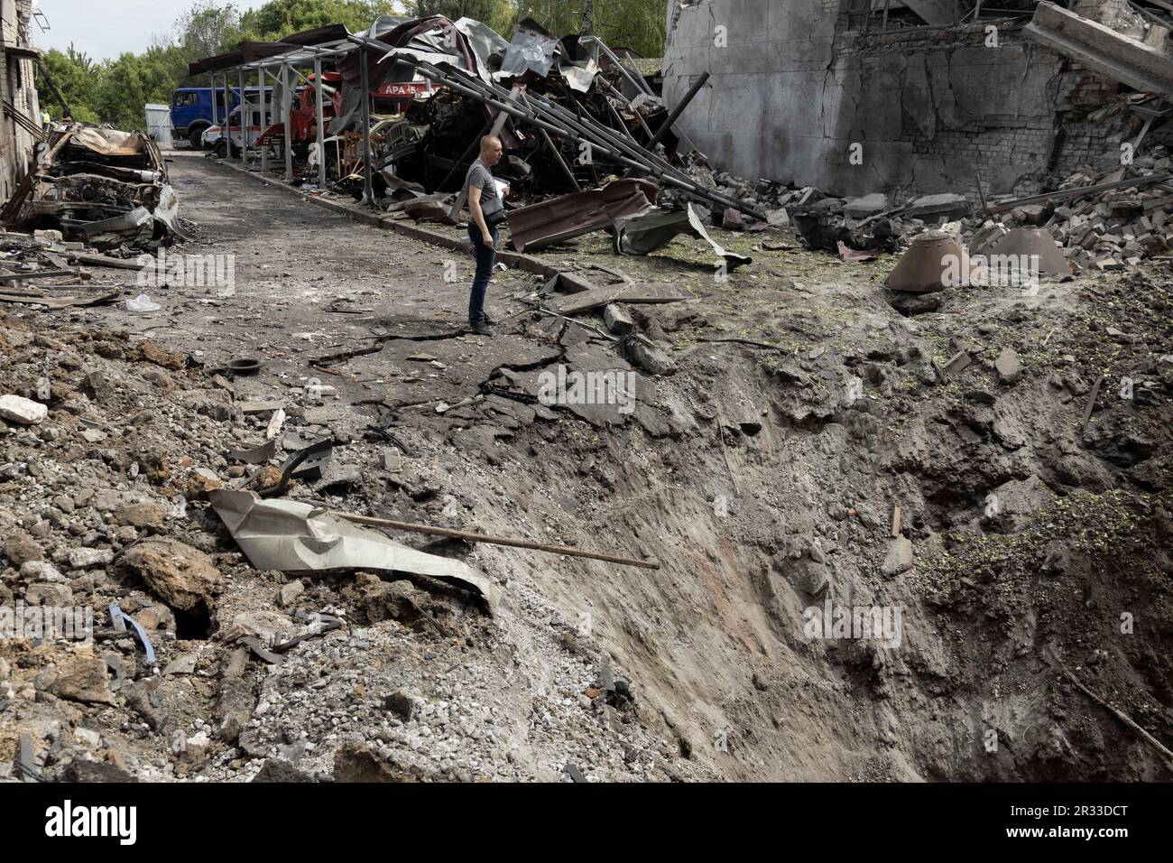 Dnipro, Ukraine. 22nd May, 2023. A man stands next to a he bomb crater ...