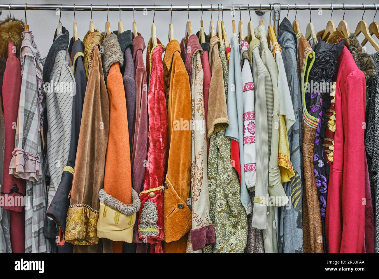Old theatrical costumes hanging on rod in row in dressing room. Movie ...