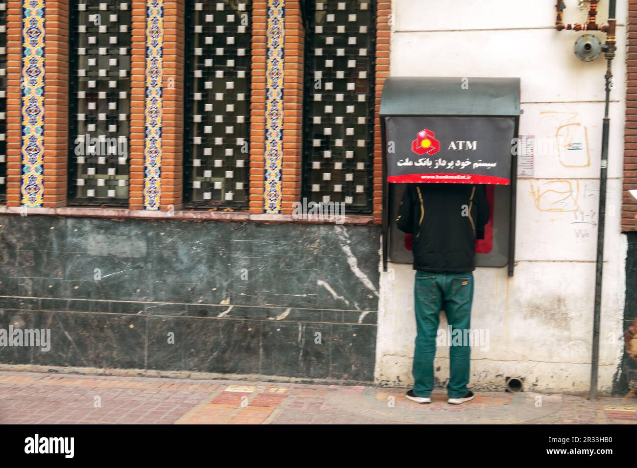 Shiraz, Iran- December 31, 2022: Unknown Iran. ATM and a person ...