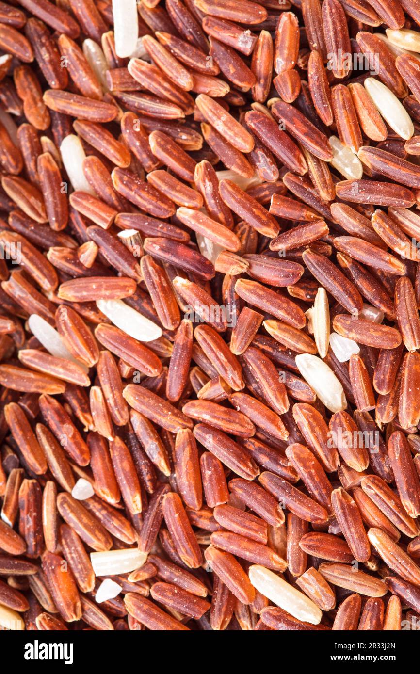 Red rice scattered as a background. Food design Stock Photo - Alamy