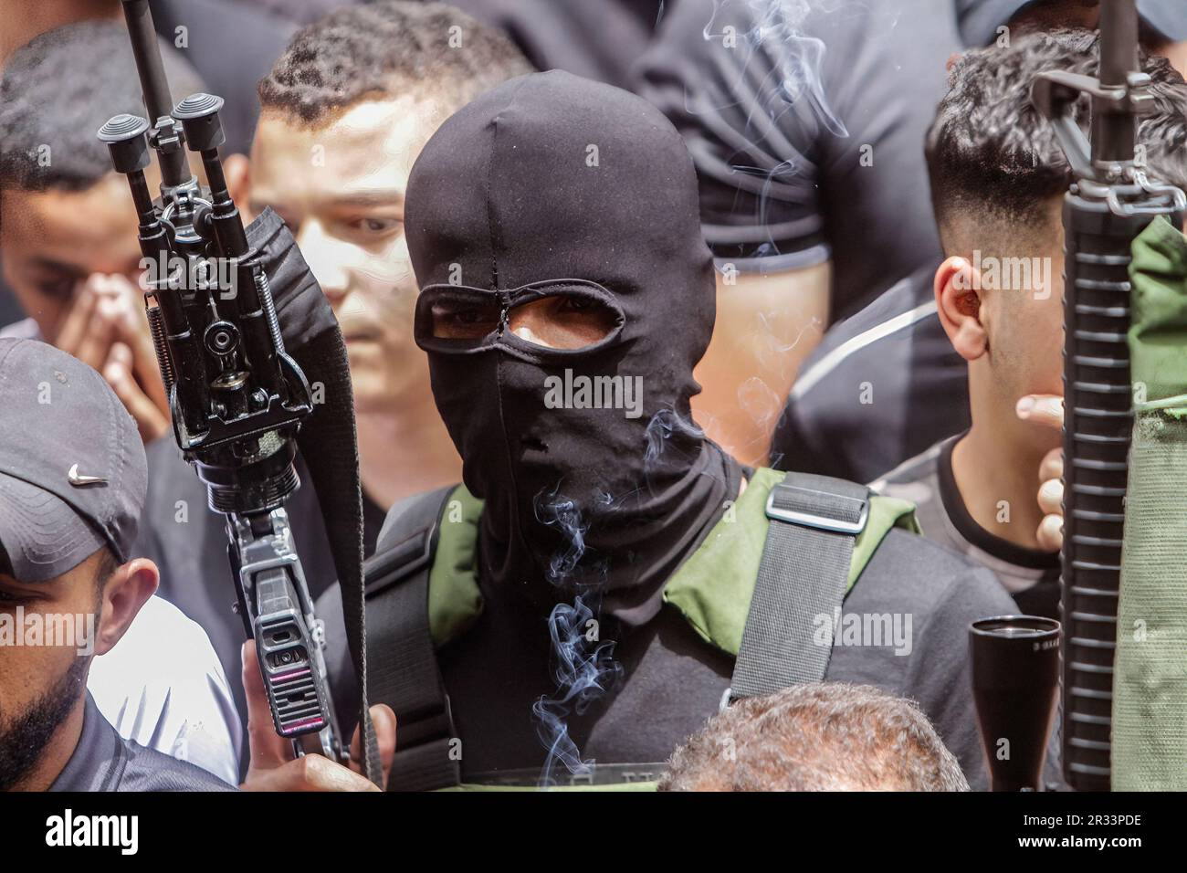 A masked gunman seen smoking during the funeral of the three ...