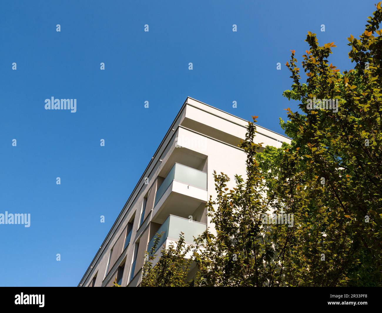 Residential building facade with balconies and glass railings. The sky ...