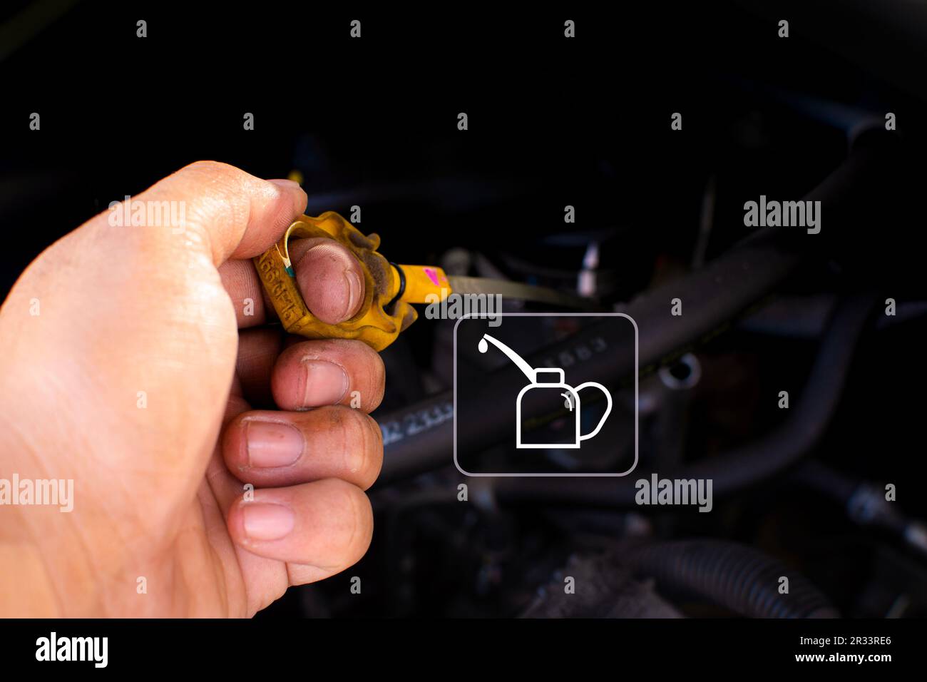 A mechanic check the car engine oil level by pulling the dipstick, motor oil symbol, copy space ...