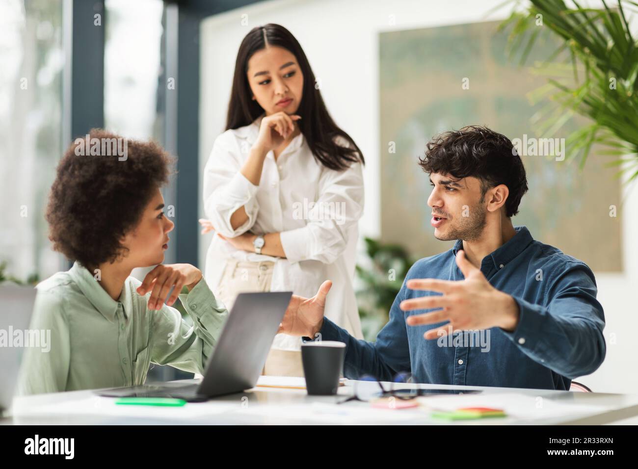 Three Coworkers Discussing Business Ideas At Work Meeting In Office ...