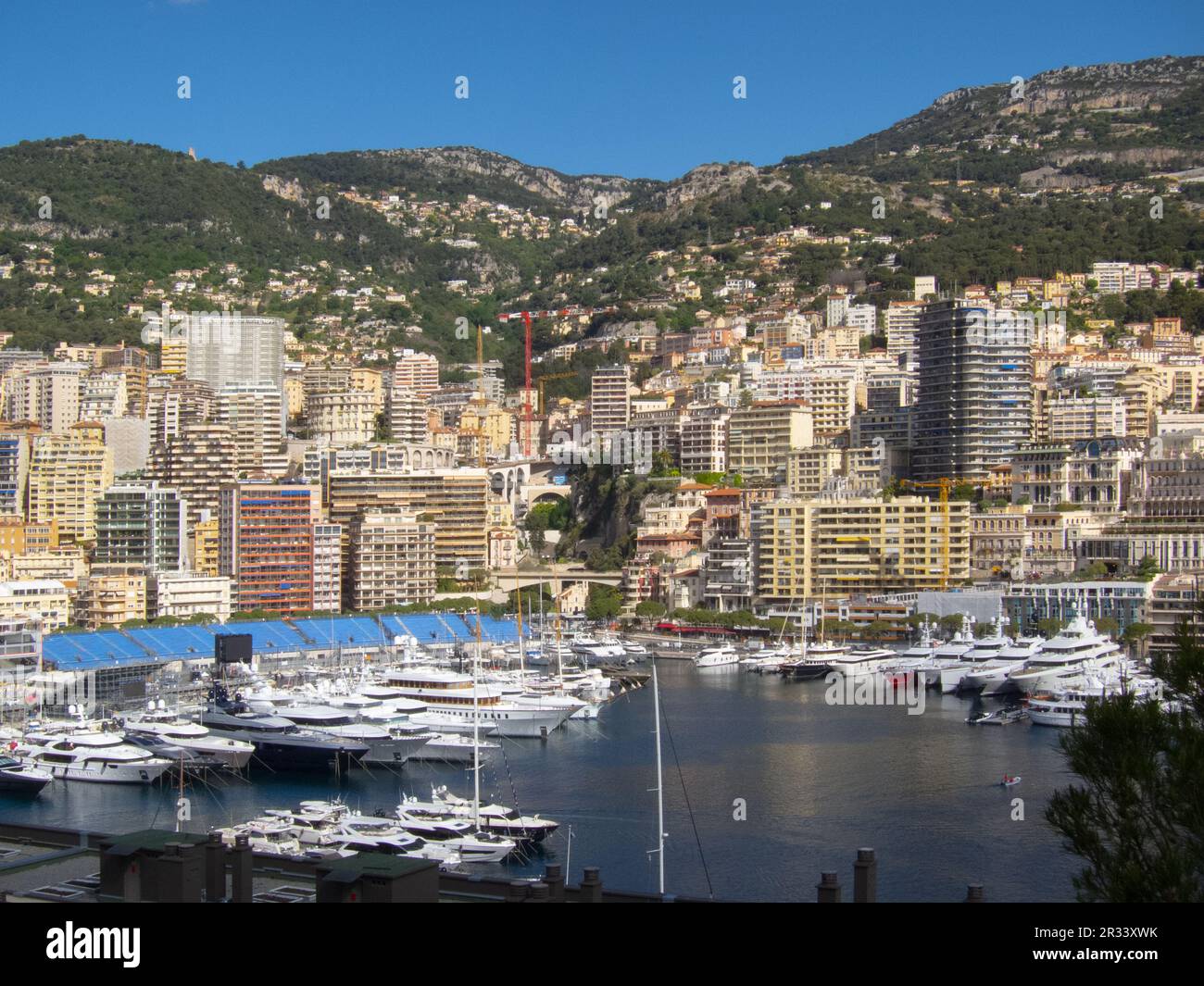 Yachts docked at Monaco's harbor, with hills in the background Stock ...