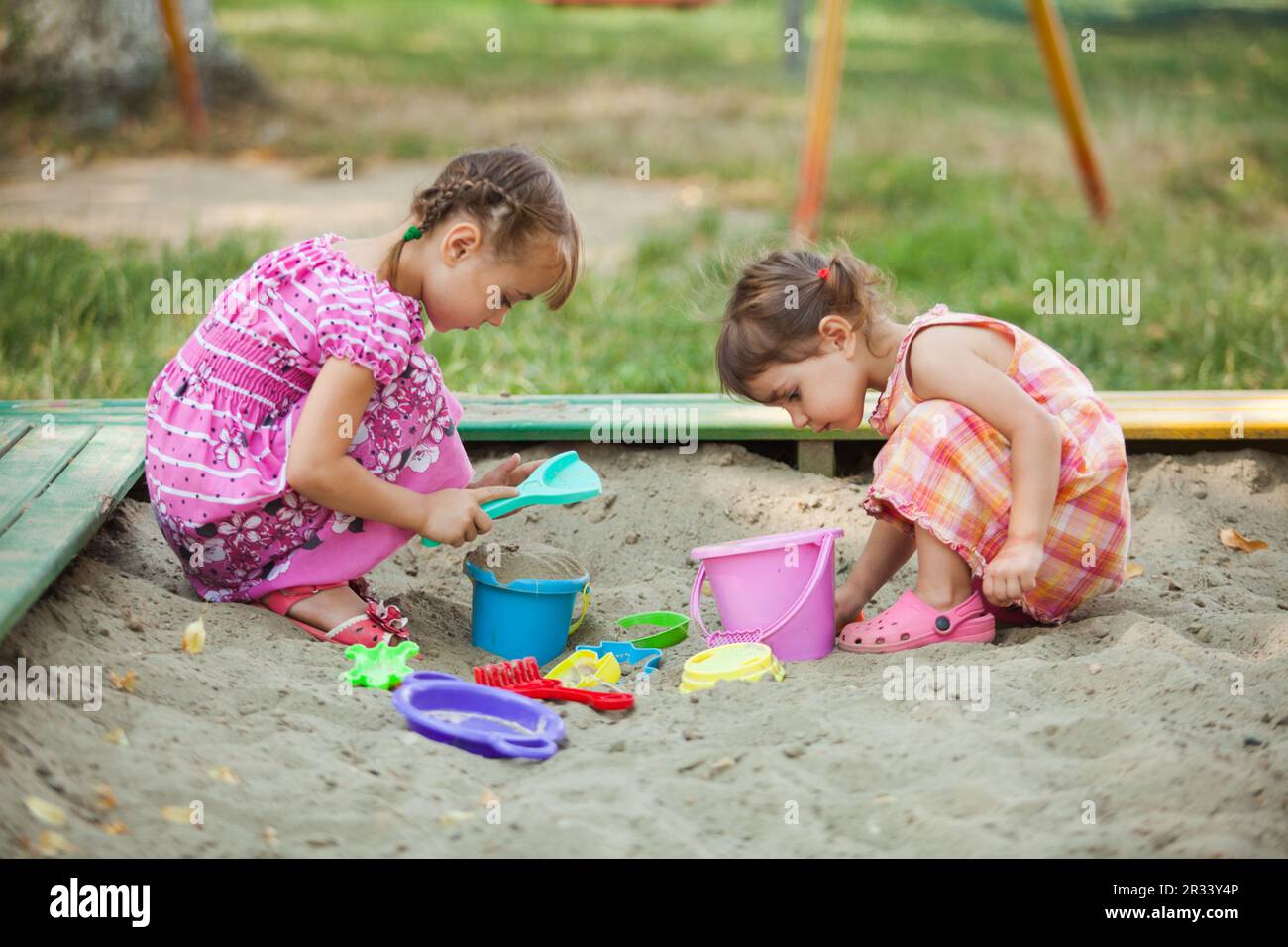 Two girls play in the sandbox Stock Photo - Alamy