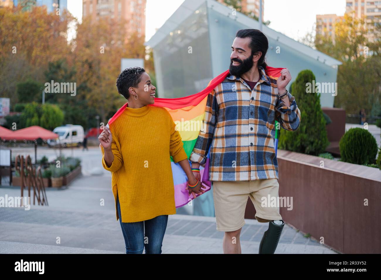 Young couple with the rainbow flag defending the rights of lgtbi people ...