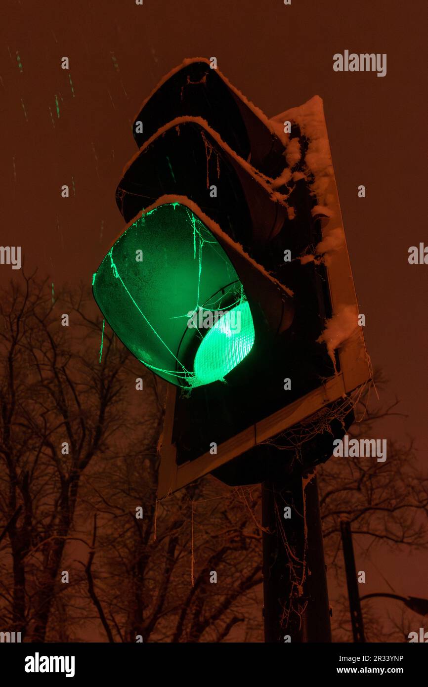 A traffic light shows green on a snowy winter night on Mill Road ...