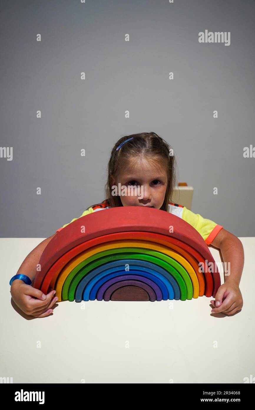 A girl peeks out from behind a huge rainbow constructor. Mental ...