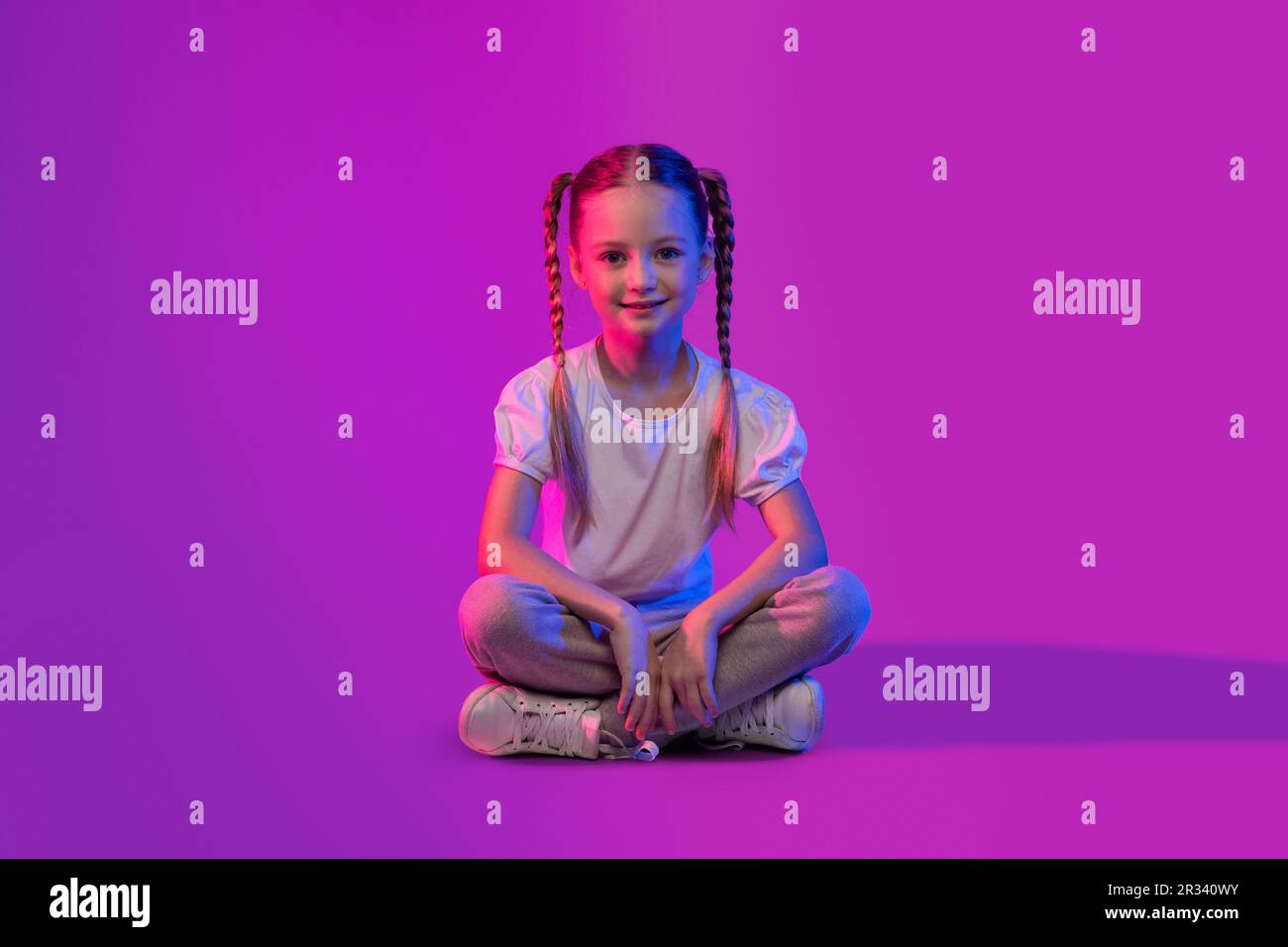 Cute pretty little girl chilling on luminous background Stock Photo - Alamy