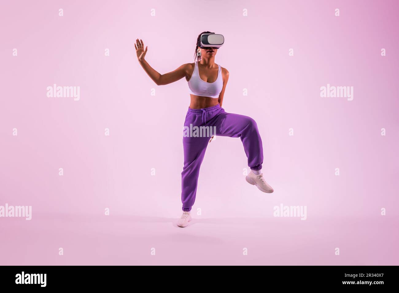 Enhancing fitness through vitual reality. Active black woman with VR ...