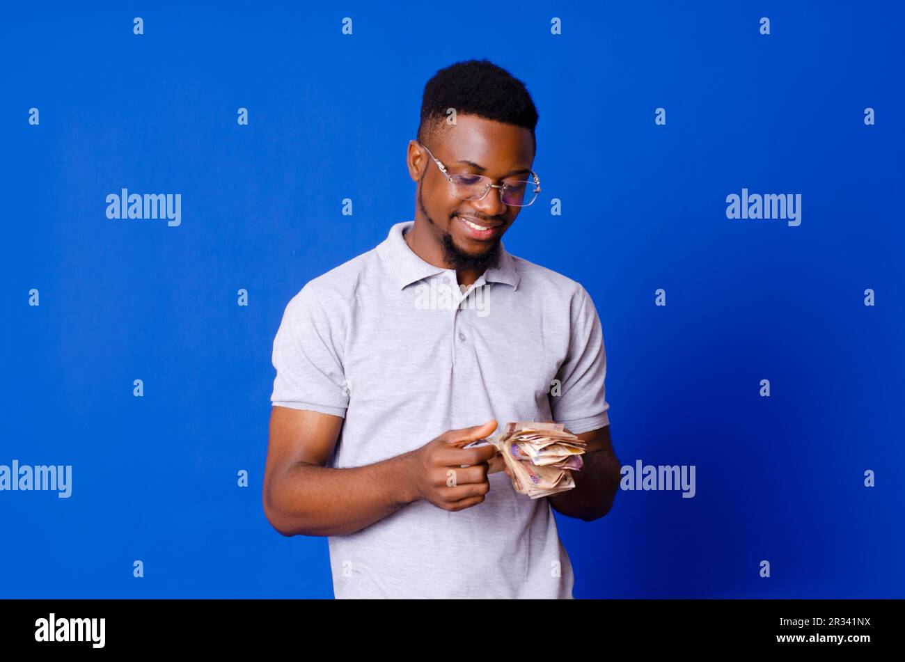 Young good looking African man counting cash and smiling Stock Photo ...
