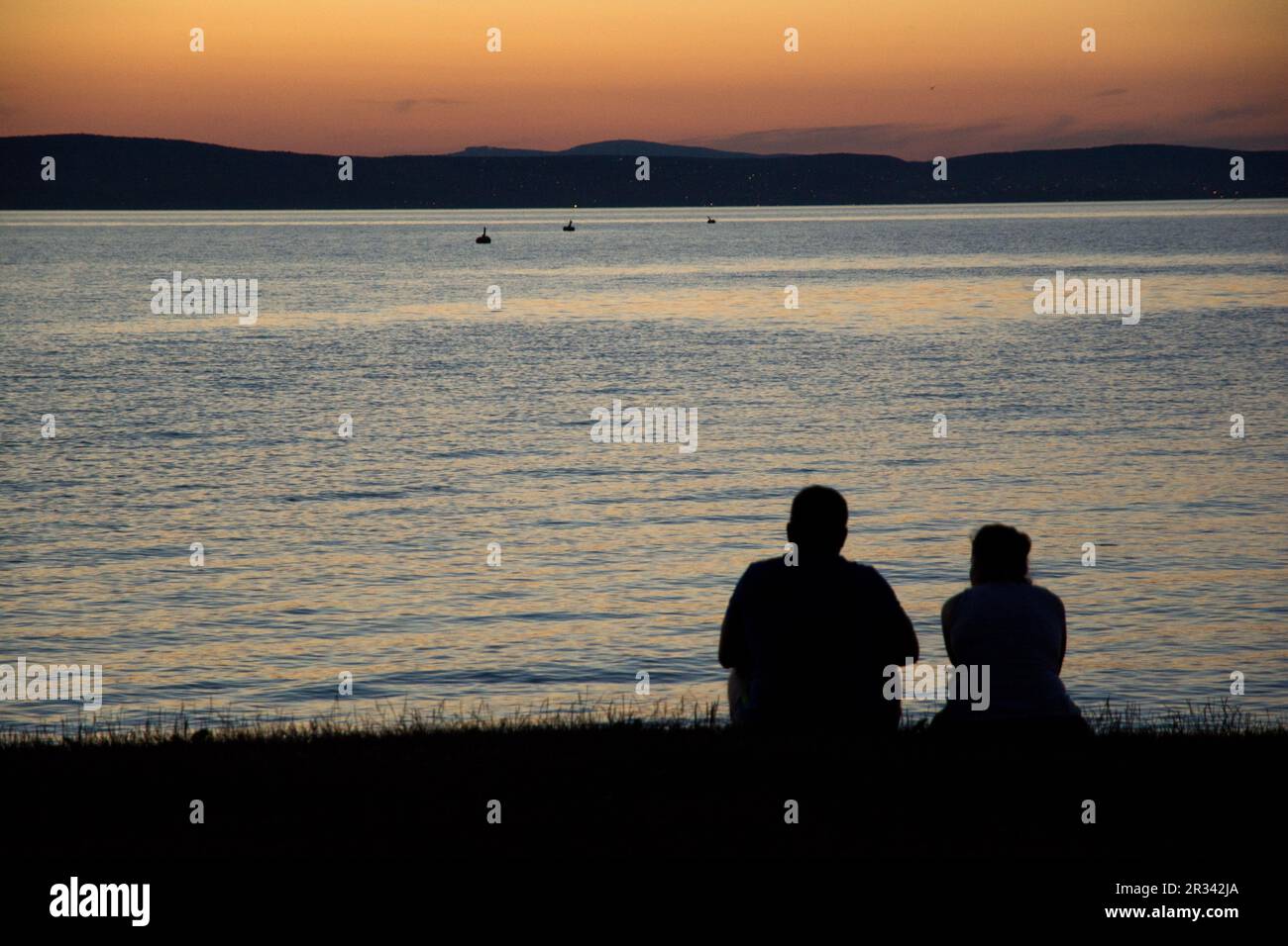 Friends sitting on beach sunset hi-res stock photography and images - Alamy