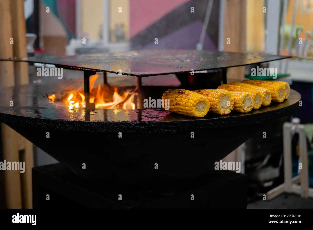 Process of grilling healthy yellow corn cobs on brazier at street food ...