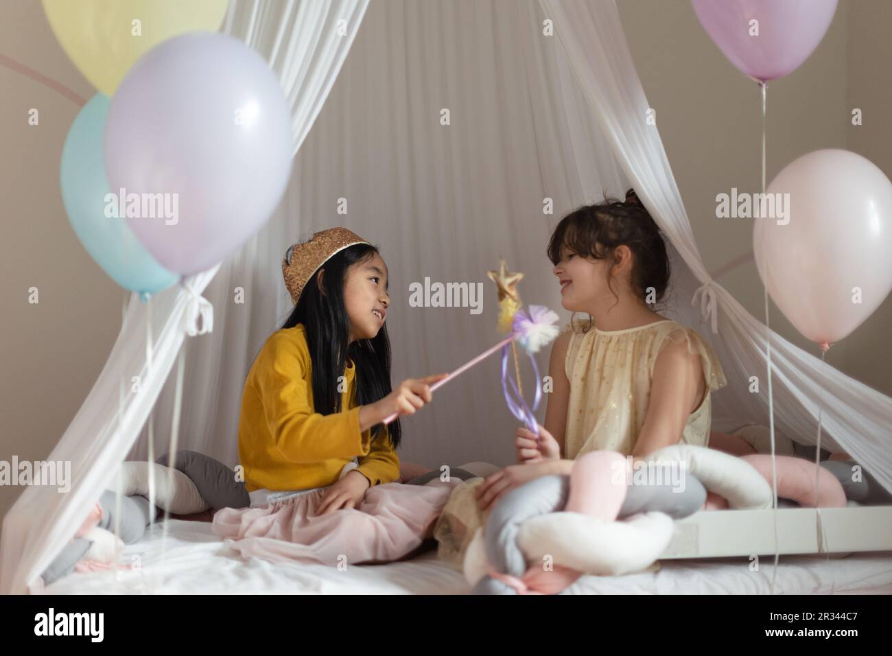 Happy girls playing princess with princess wands in a play tent Stock ...