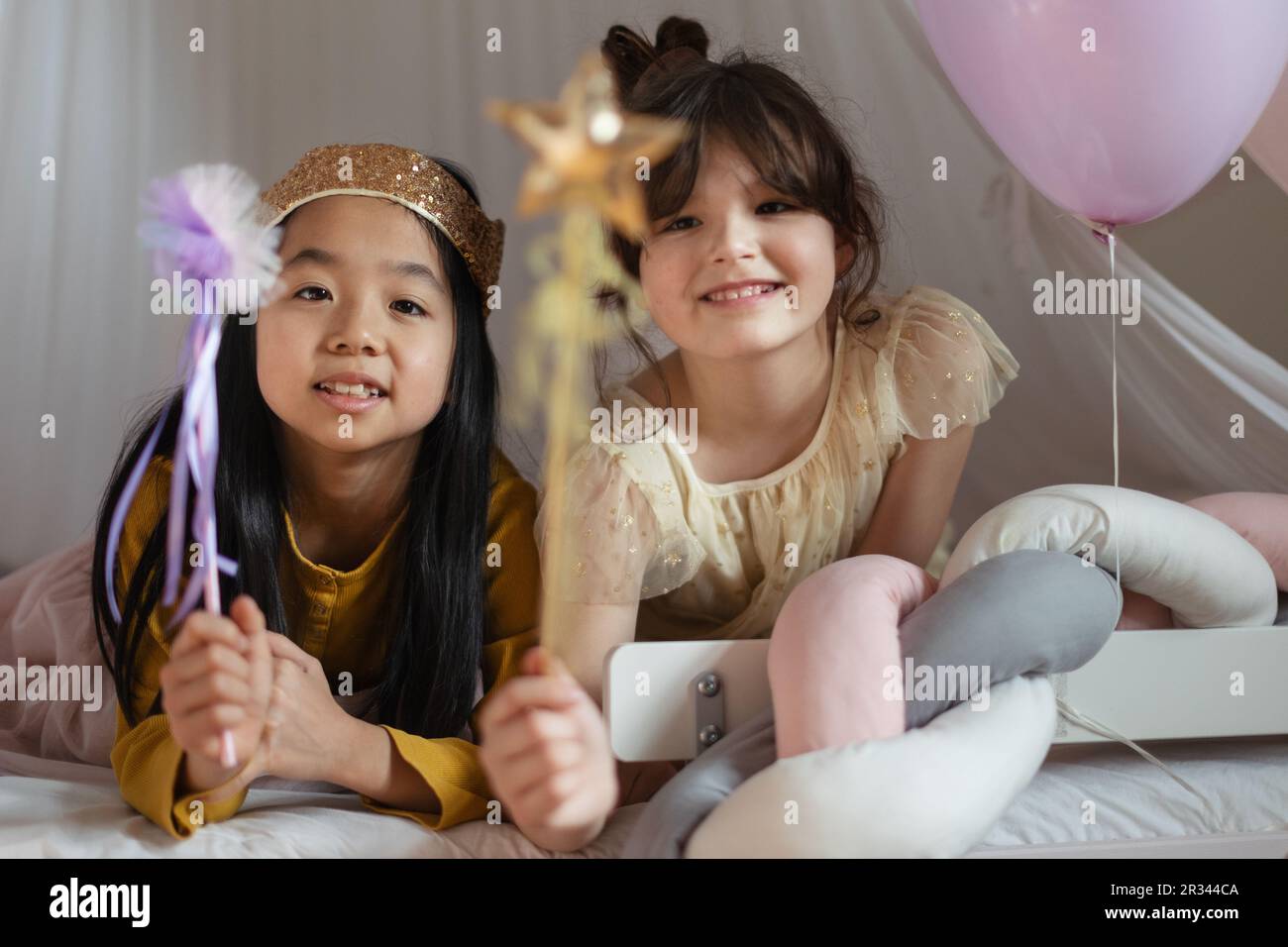 Happy girls playing princess with princess wands in a play tent Stock ...