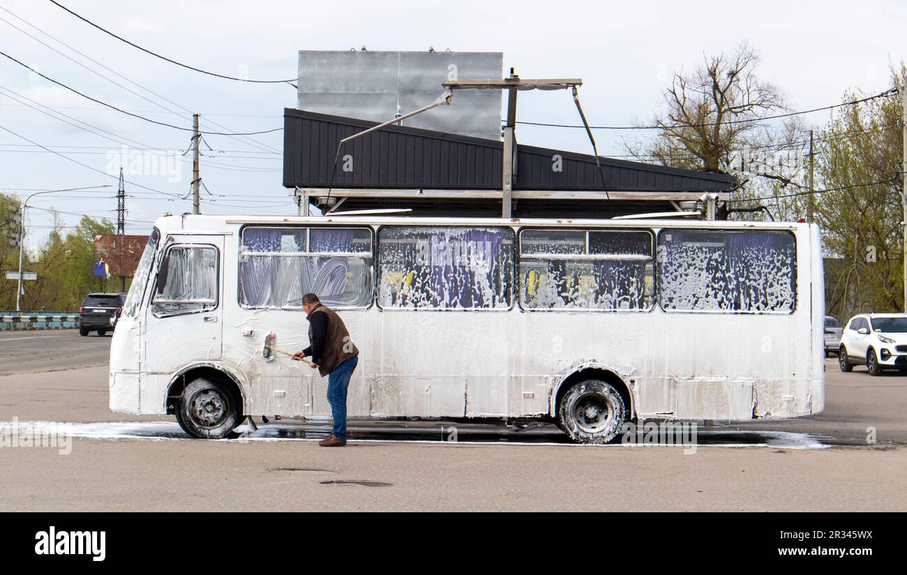Big white bus in foam at a self-service car wash. External washing of ...
