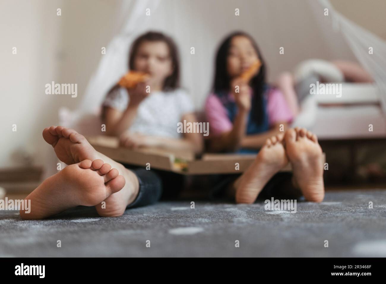 Friends sit on the floor with pizza box in their lap Stock Photo - Alamy