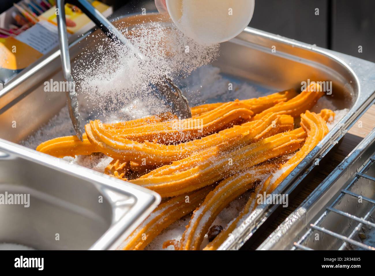 Chef preparing homemade crunchy churros at street food market: close up ...