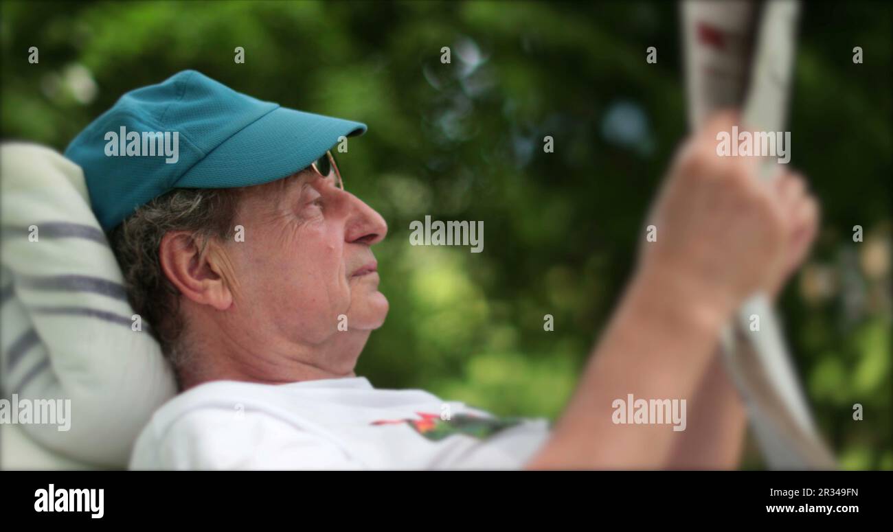 Older man enjoying retirement reading newspaper outside in park Stock ...