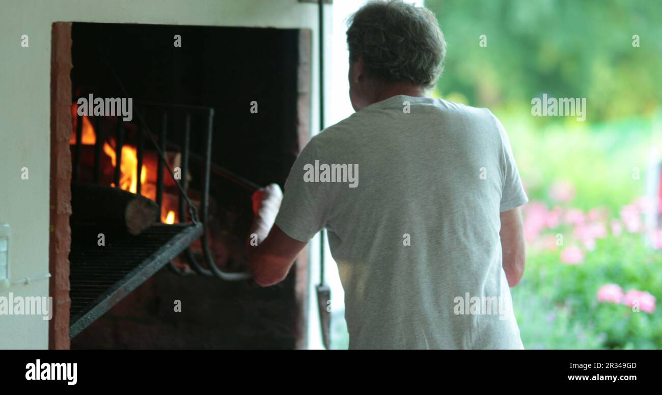 Older man preparing BBQ grill at home, candid real life senior retired ...