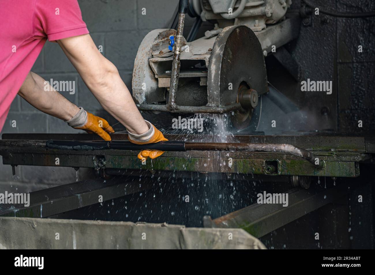 A worker cuts granite. The cutter cuts granite. Stone processing ...