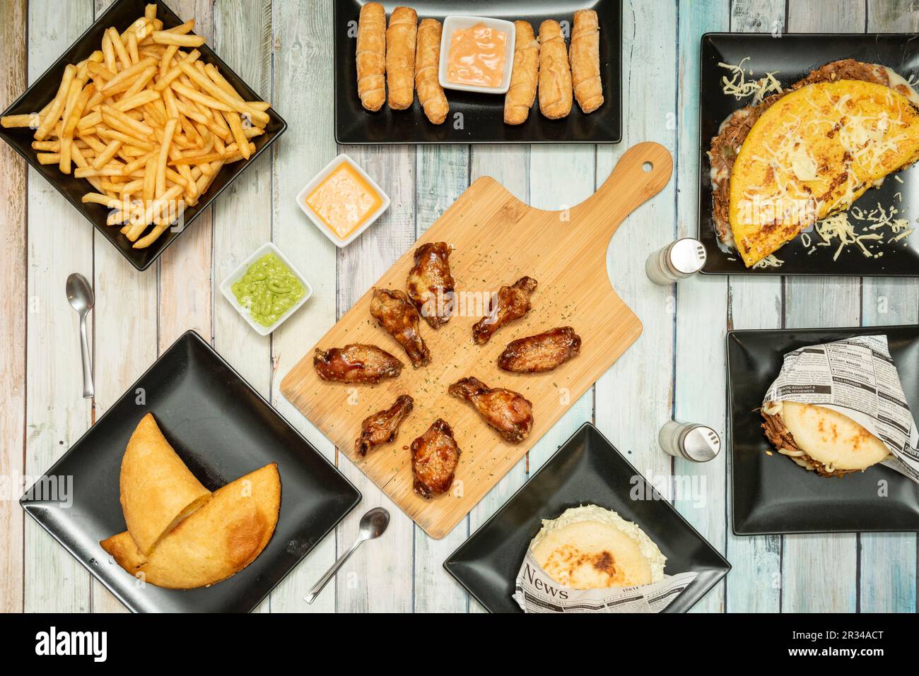 Set of fast food dishes, with a tray of chips, Venezuelan cachapa ...