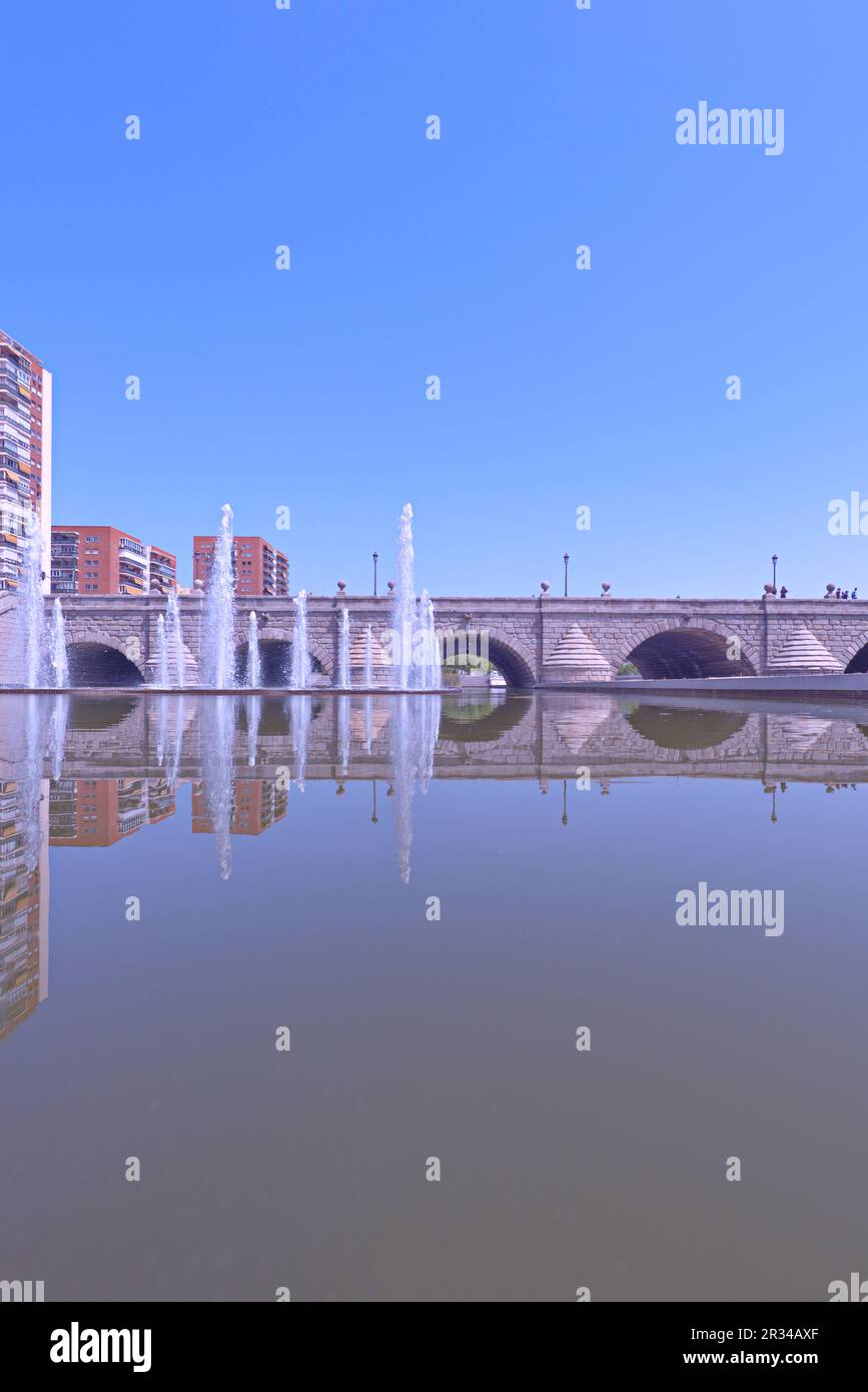 Segovia old stone bridge in the center of Madrid with water reflecting ...