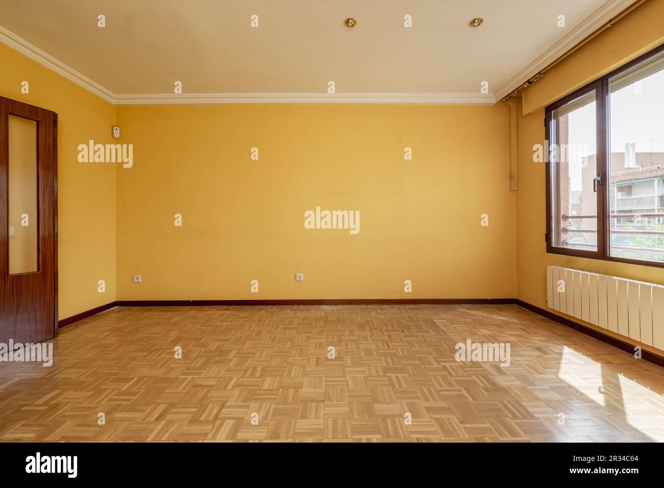 An empty hall with sapele wood double doors with windows in front and ...