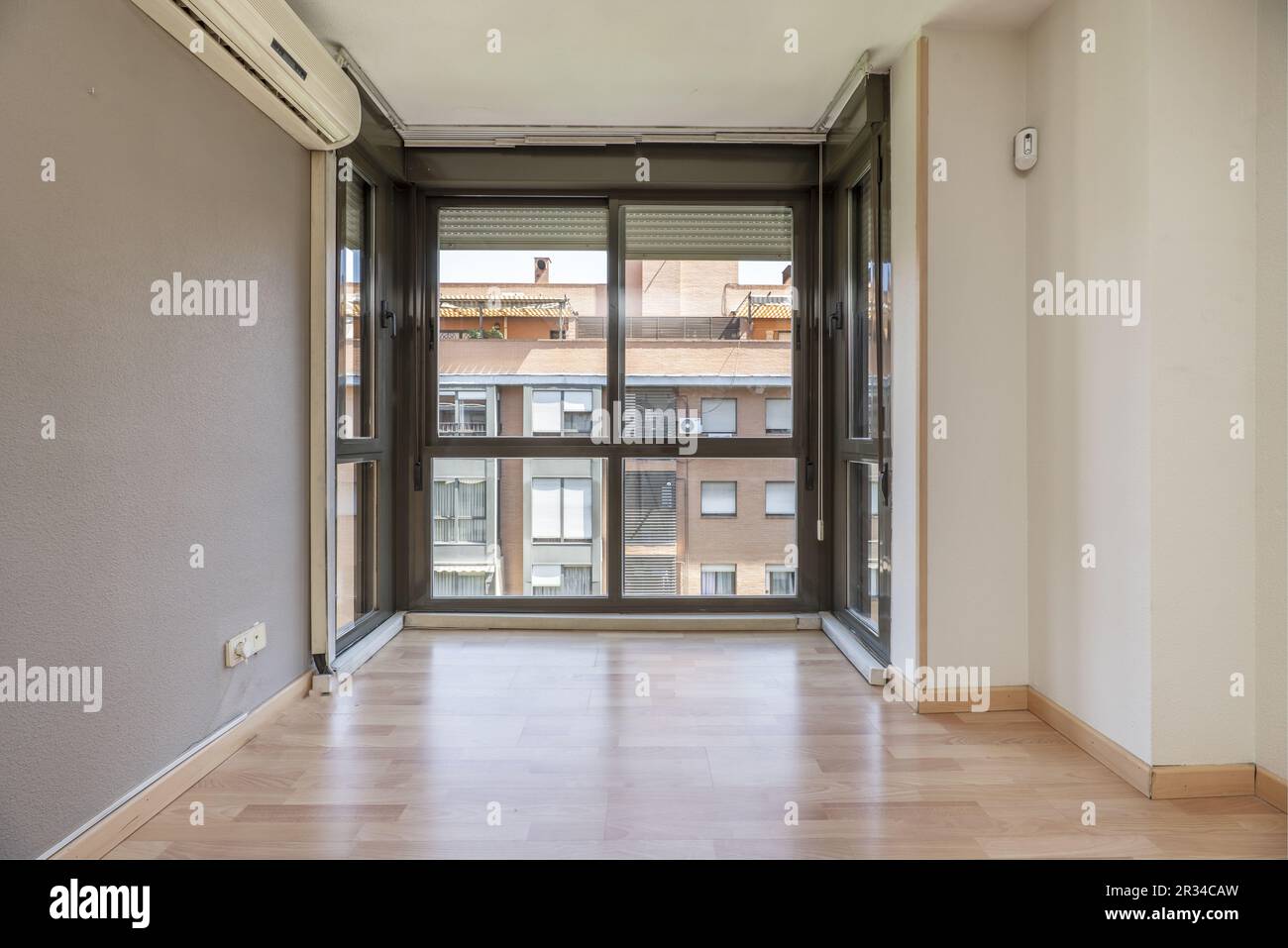 An empty window front living room with air conditioning, wooden floor ...