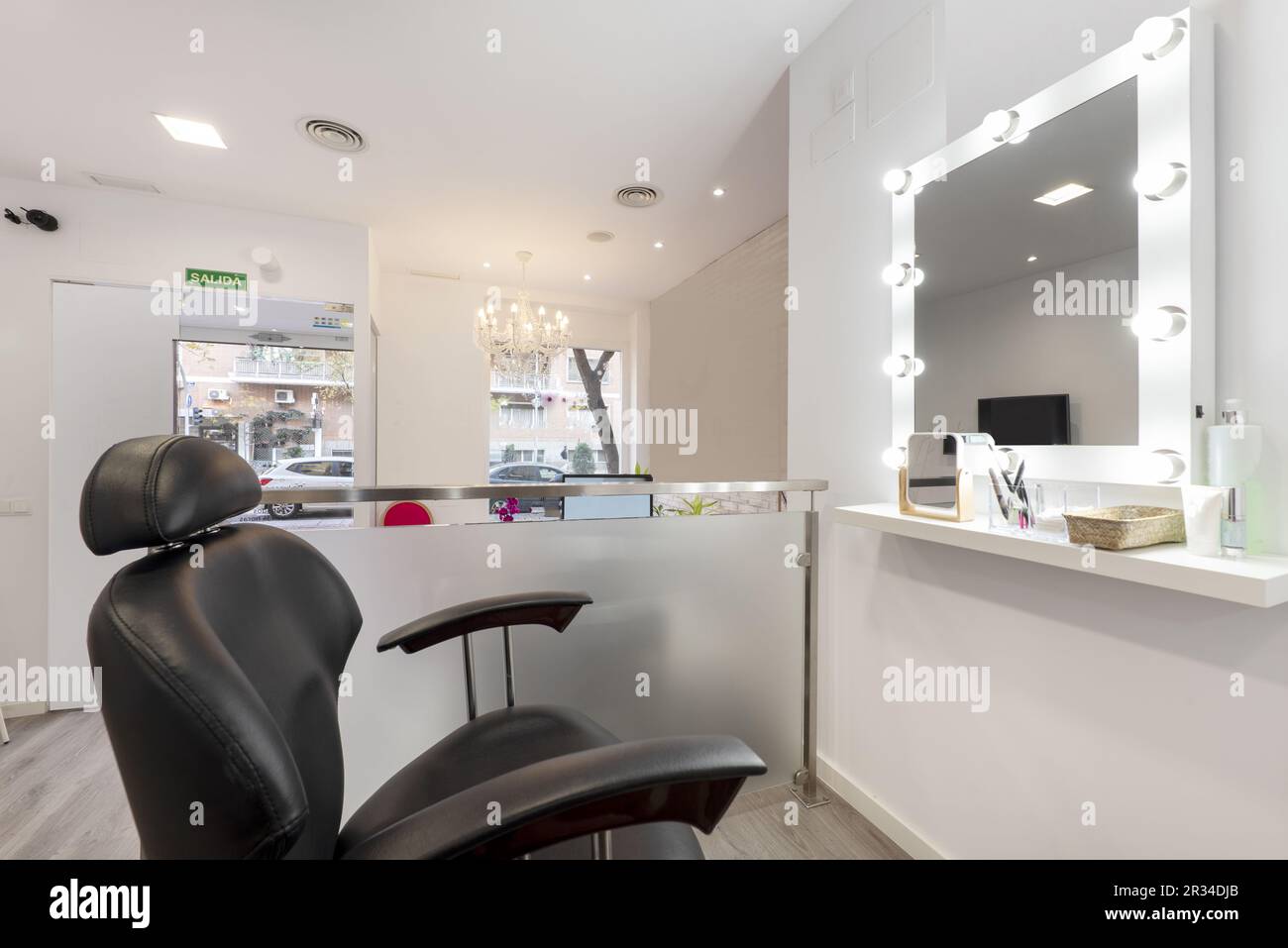 A beauty salon with a make-up booth for clients with a mirror with ...