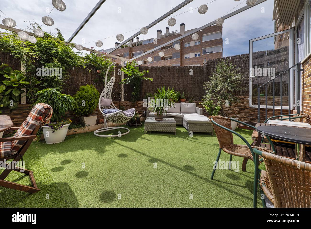 A wonderful urban terrace with lots of neat plants, wooden seats, a ...
