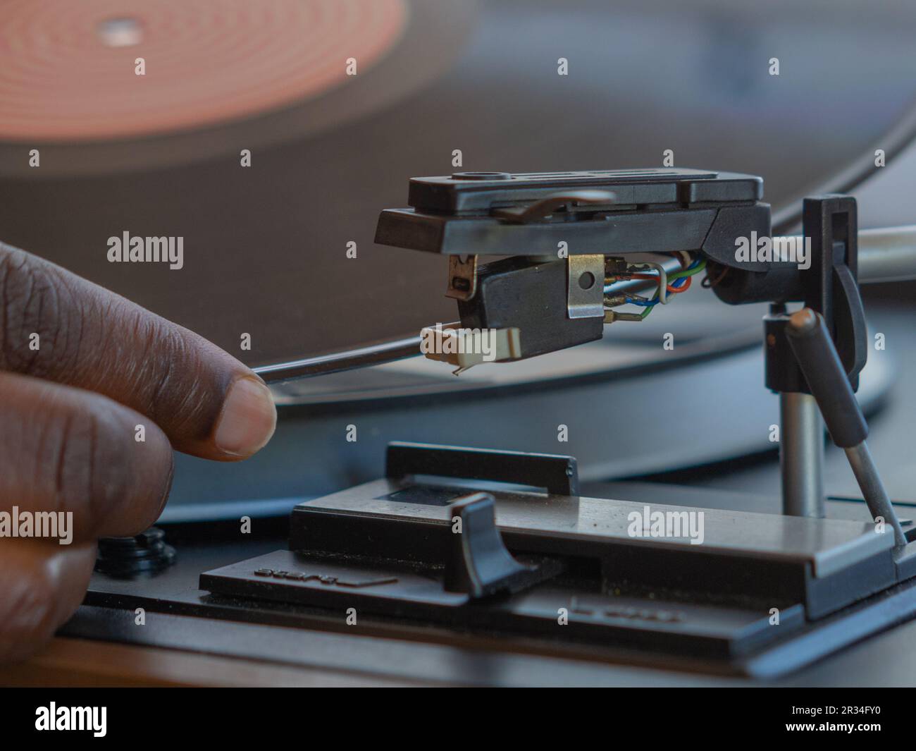 Detail of a female hand placing a black vinyl record on a vintage ...