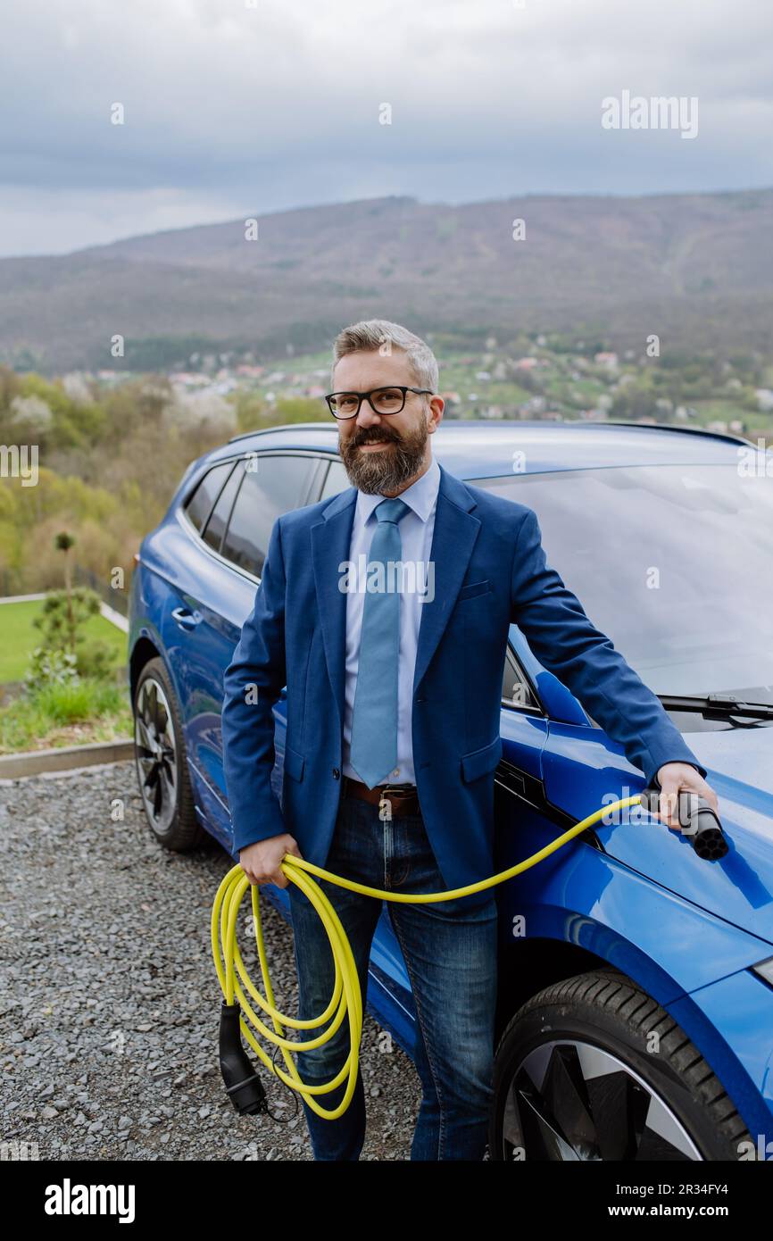 Close up of businessman holding power supply cable from his electric ...