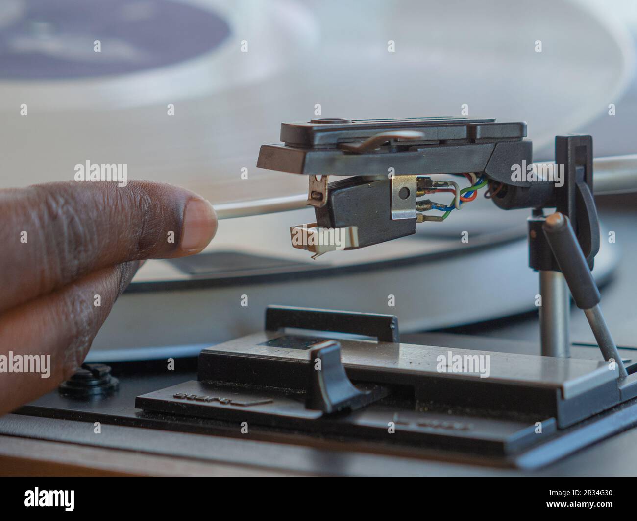 Detail of a female hand placing a white vinyl record on a vintage ...