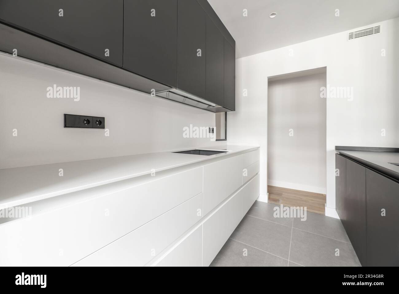 kitchen furnished with a combination of white and smooth black ...