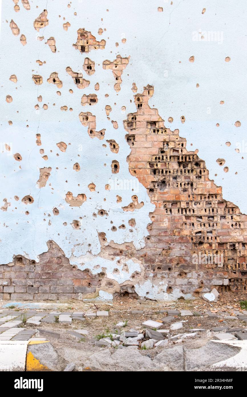 The wall of a building battered by rocket fragments in a war zone ...