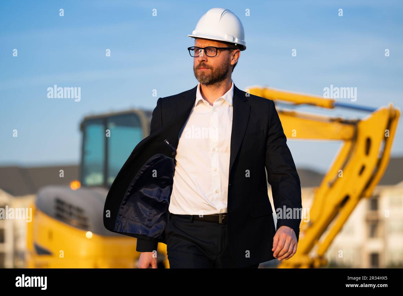 Construction owner near excavator. Confident construction owner in ...