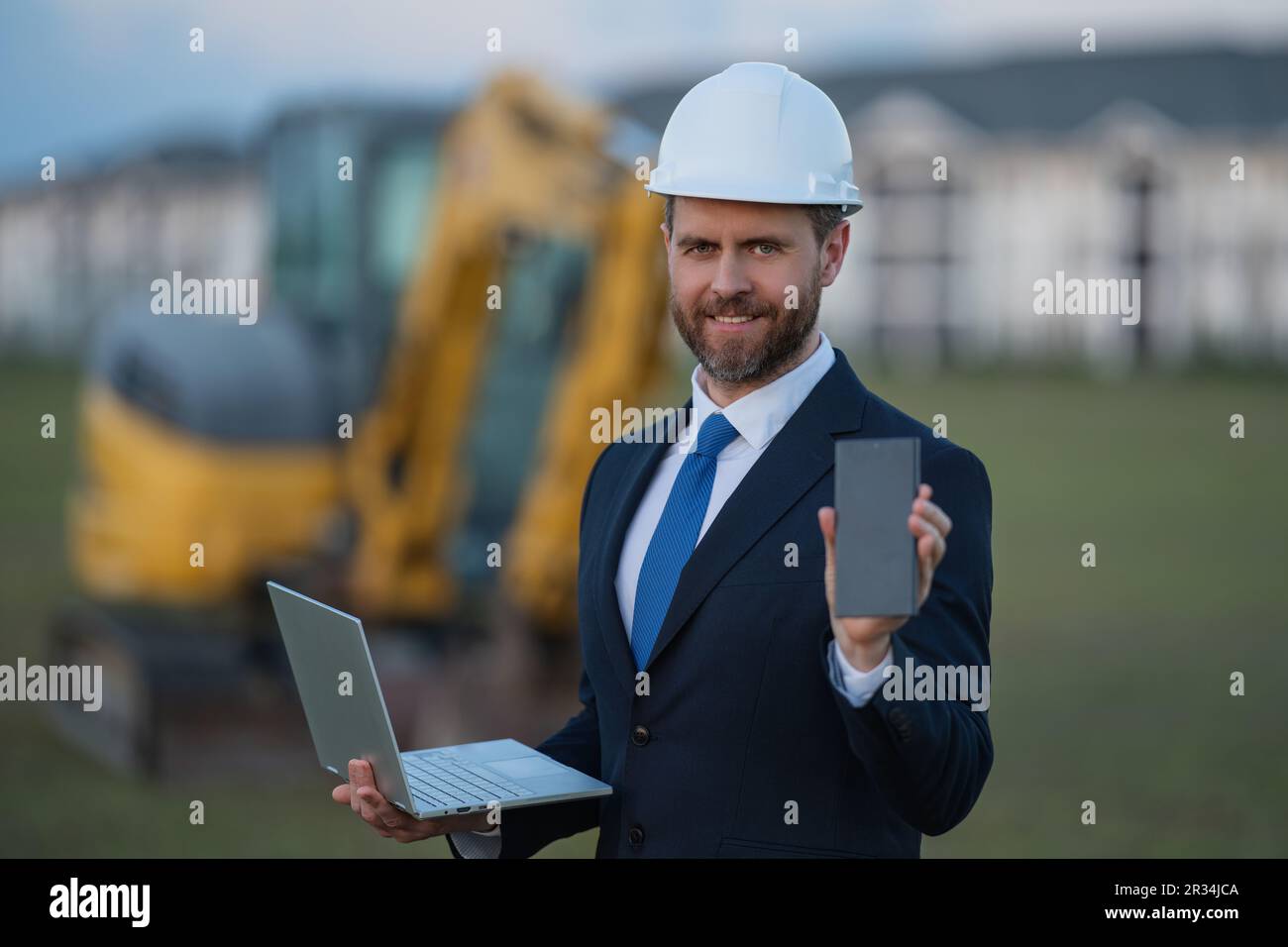 Architect at a construction site. Architect man in helmet and suit at ...