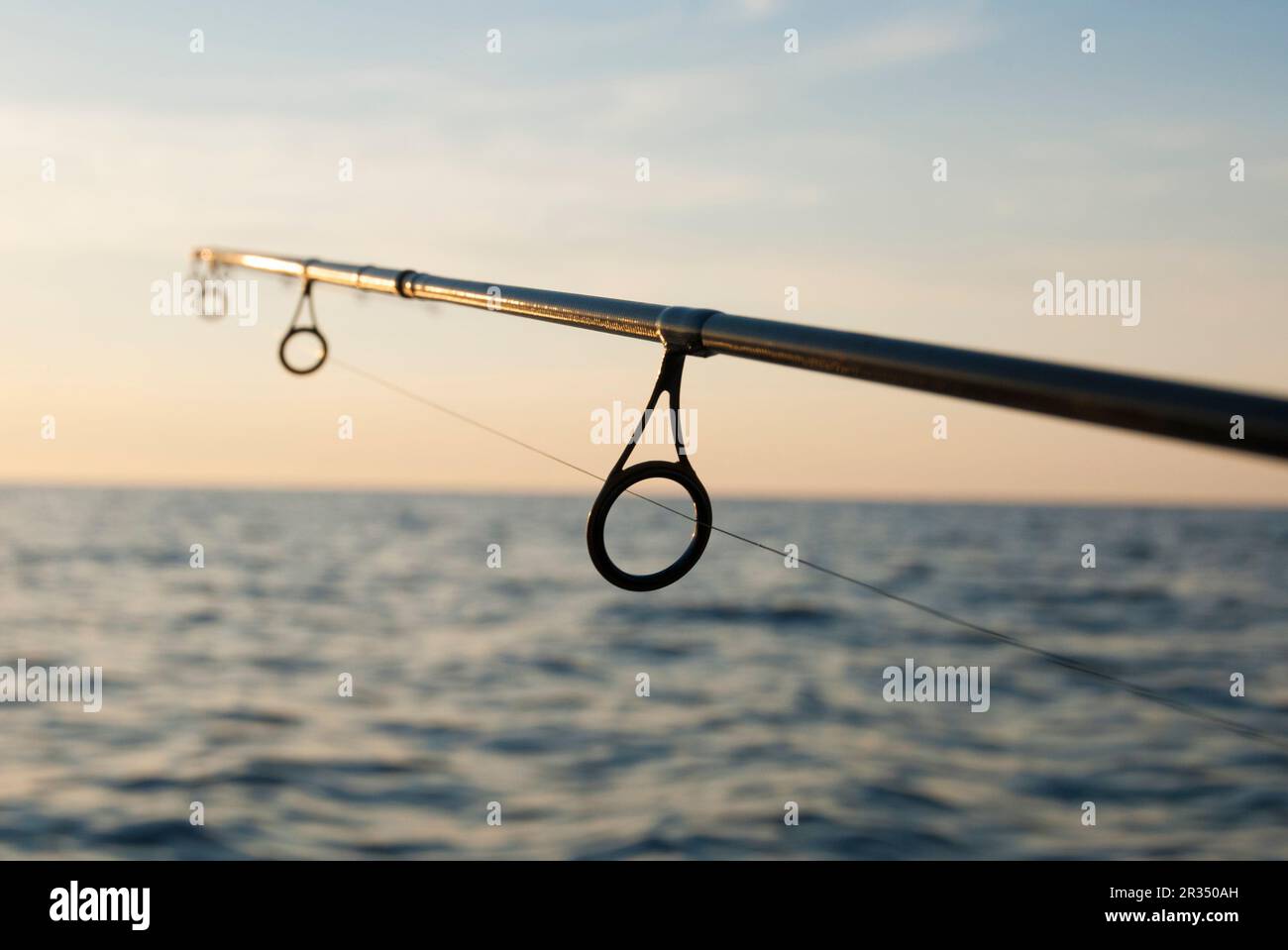 Spinning rods in front of sea water Stock Photo - Alamy