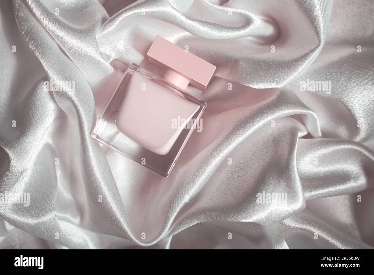 Perfume on white silk fabric Stock Photo - Alamy