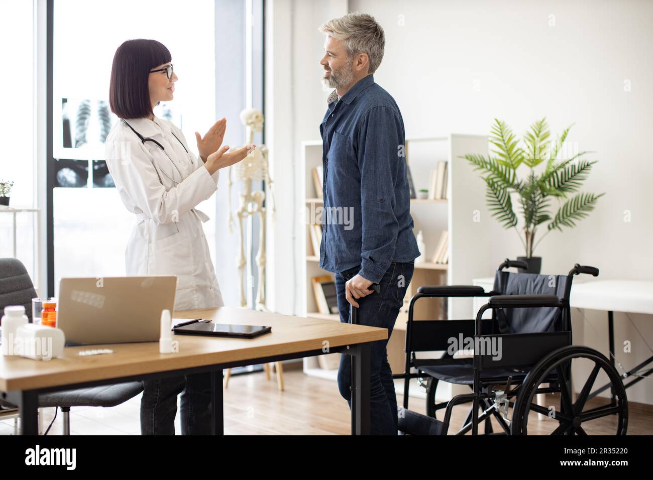 Smiling female with stethoscope clapping while happy man standing on ...