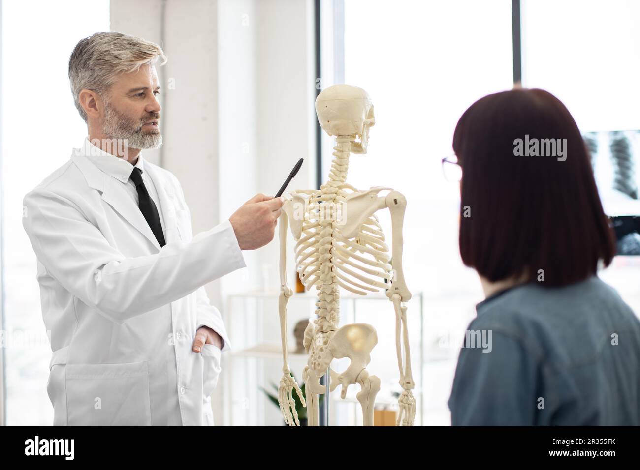 Close up of stylish male in lab coat showing neck bones to brunette ...
