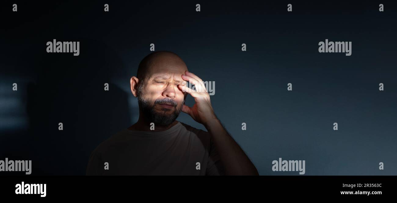 Sad man suffering from headache or migraine. Stressed guy with painful ...