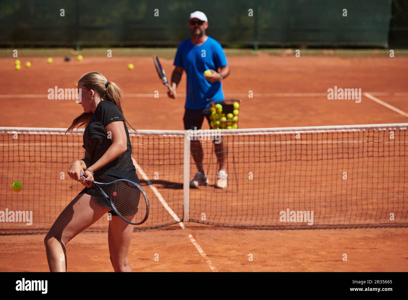 A professional tennis player and her coach training on a sunny day at ...