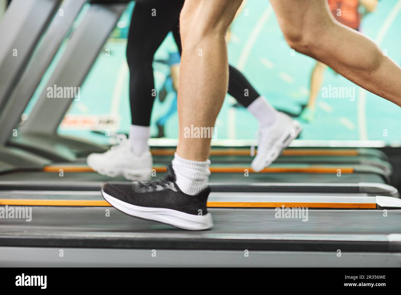 Shot of male and female legs running on treadmills in a gym Stock Photo ...