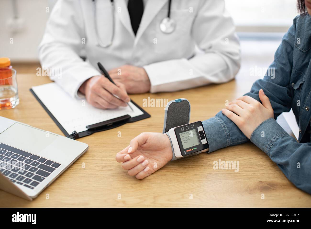 Cropped view of woman's wrist with electronic tonometer showing numbers ...