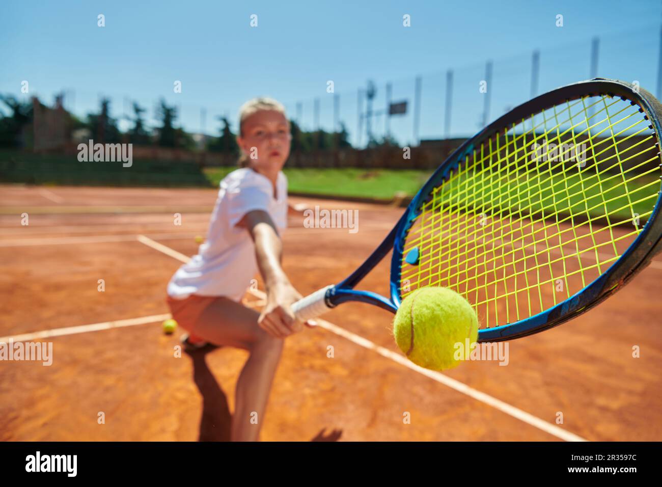 Close up photo of a young girl showing professional tennis skills in a ...