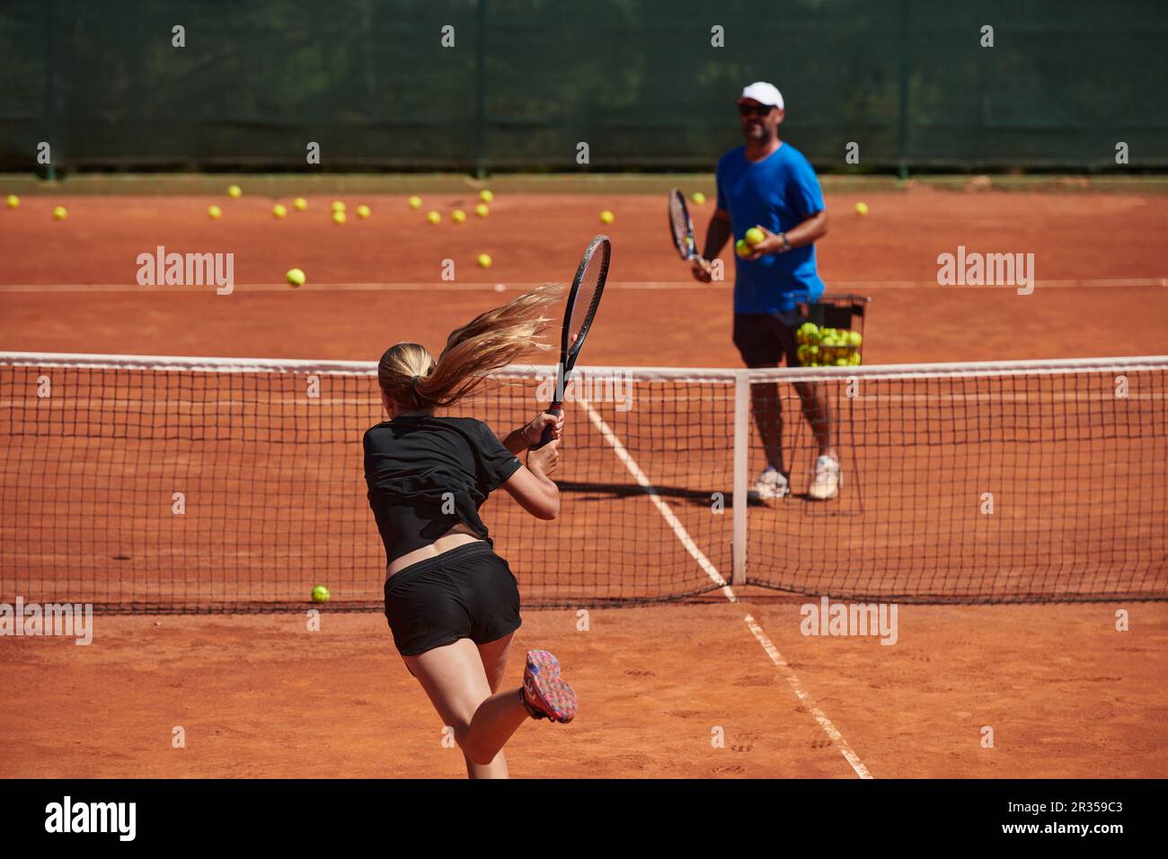 A professional tennis player and her coach training on a sunny day at ...